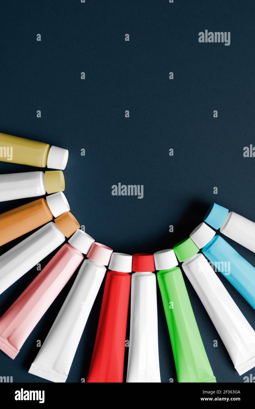 Container of coloured tubes on dark background placed in a semi-circle ...