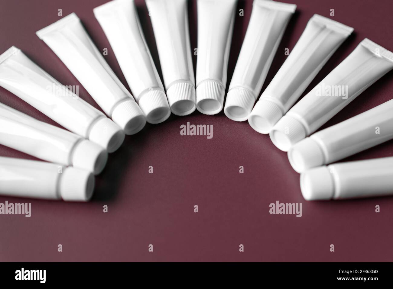 Container of white tubes on dark background placed in a semi-circle and ...