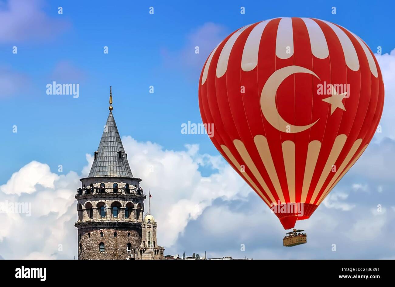 Tourists ride hot air ballon above Galata tower . Istanbul city in ...