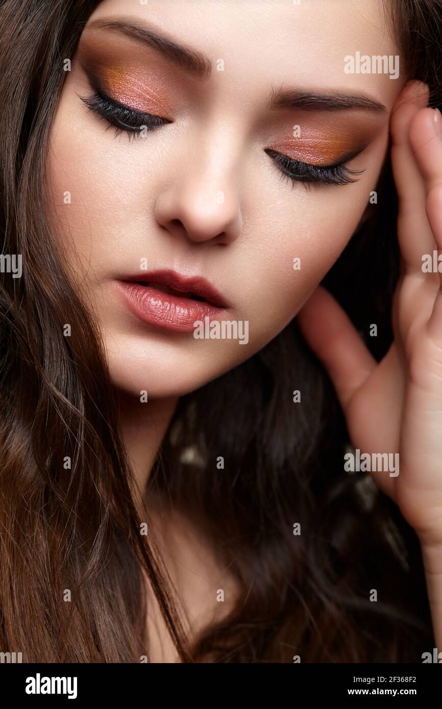 Beauty portrait of young woman with hand near face. Brunette girl with ...