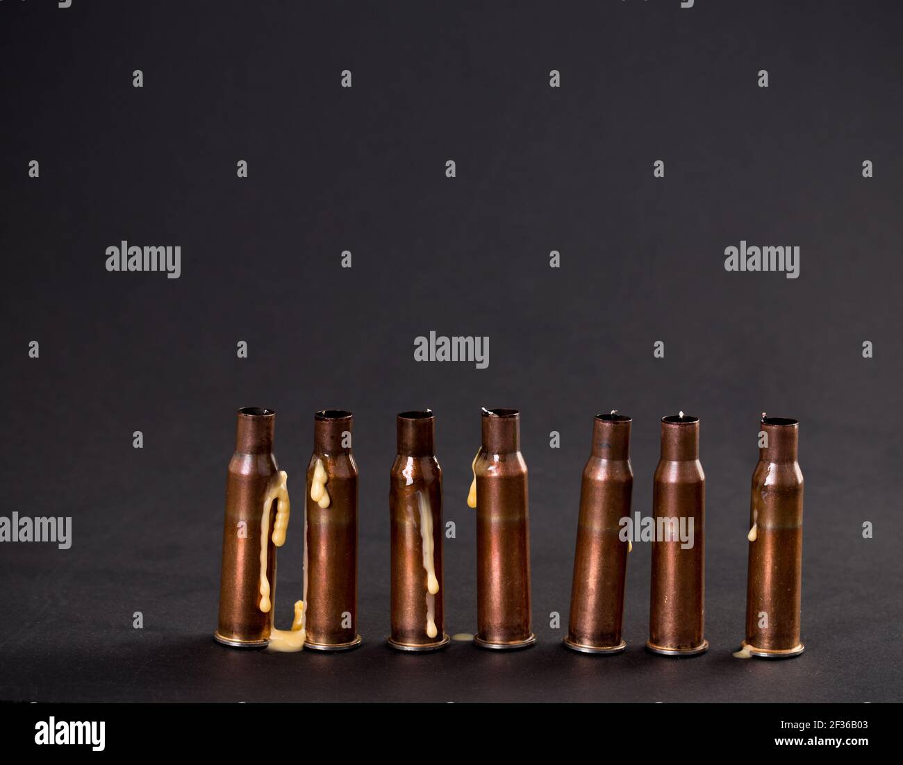 Empty rifle cartridges with melted candles. As a symbol of war and ...