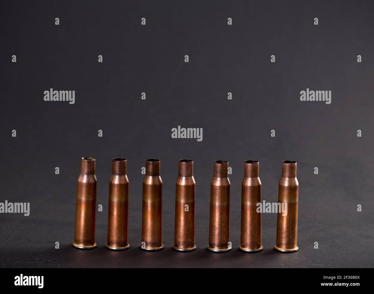 Empty rifle copper cartridges against black cardboard as a background ...