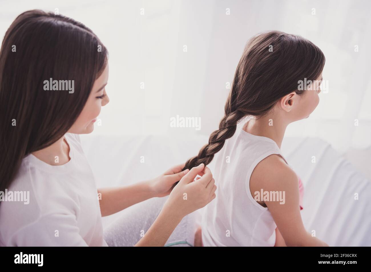 Photo of pretty charming two sisters sleepwear sitting bed having rest ...