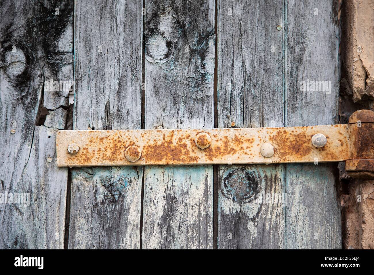 Old rusty hinge on an old wooden door painted blue. Detail of the ...