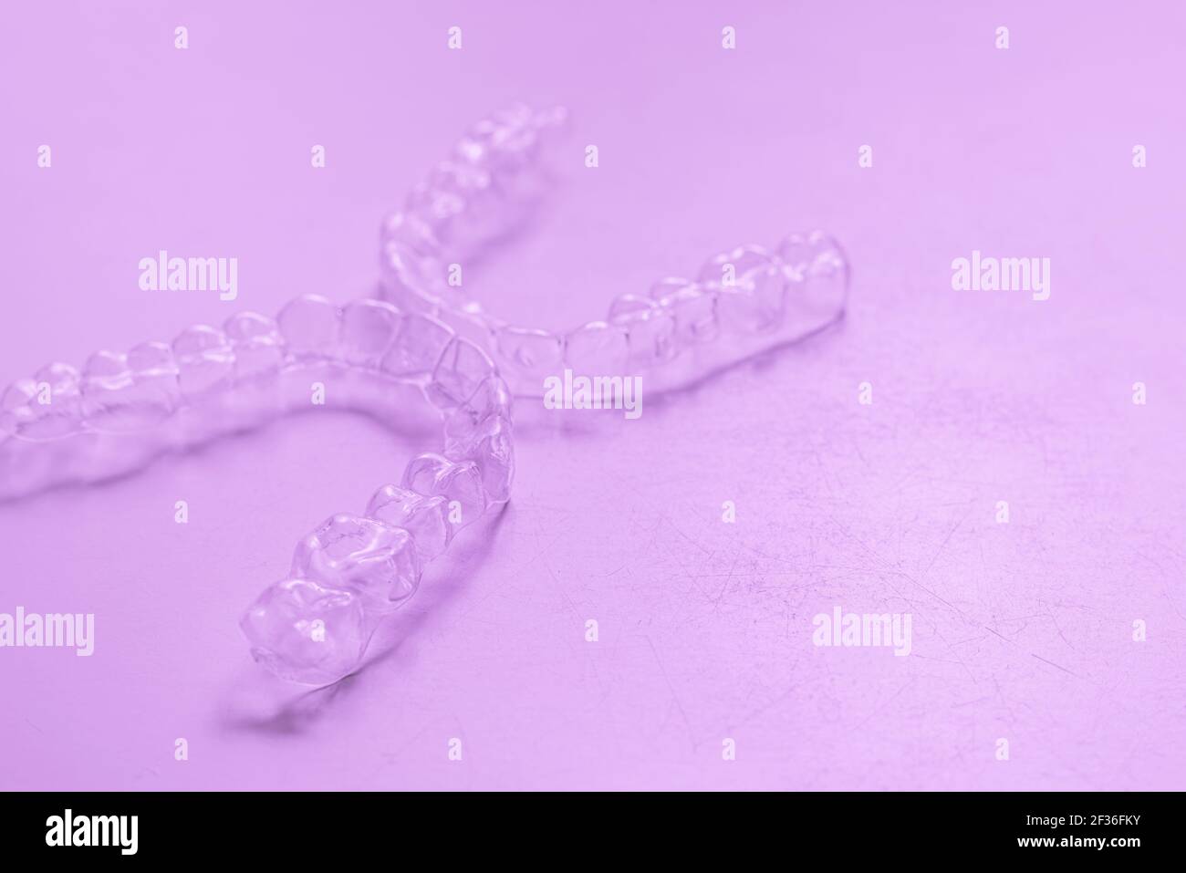 Invisible aligner teeth retainers on a pink background Stock Photo - Alamy