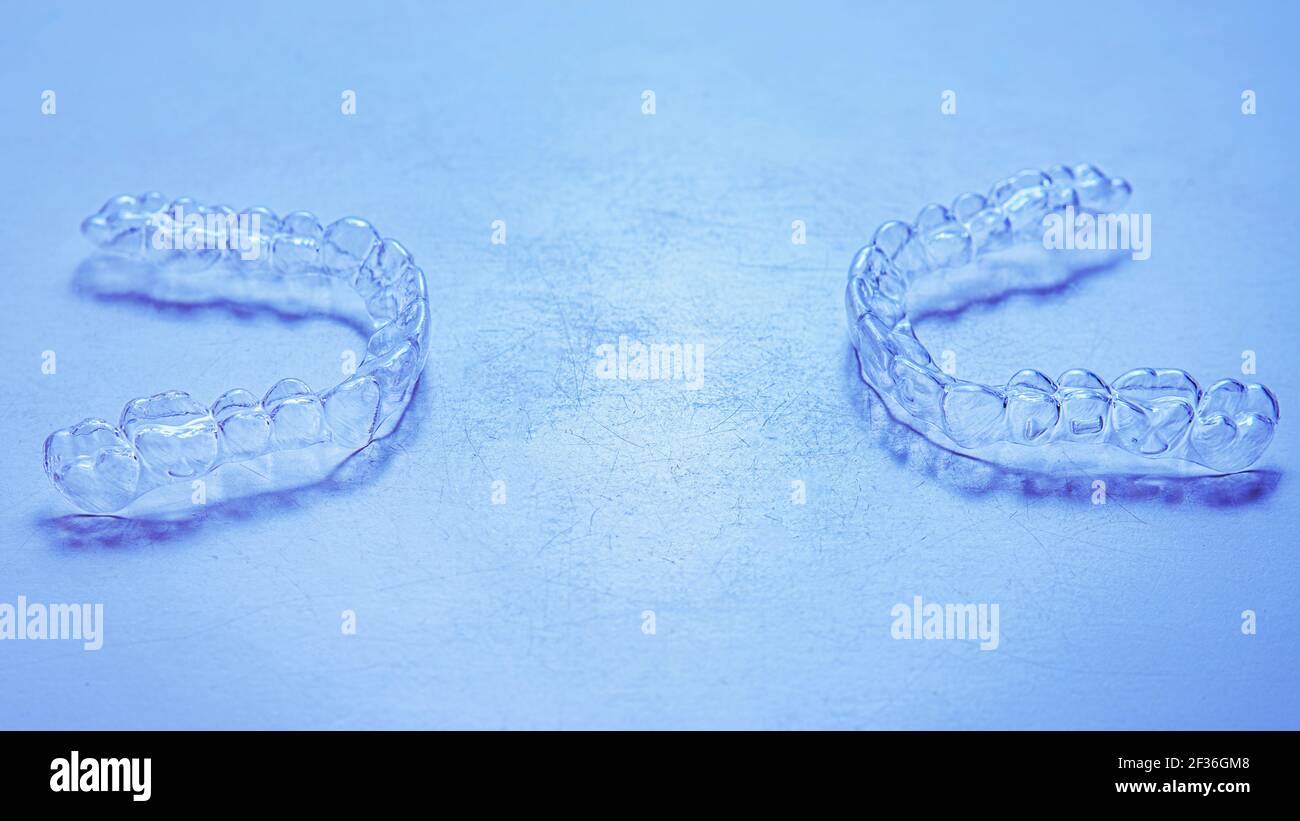 Invisible dental teeth brackets tooth aligners on blue background ...