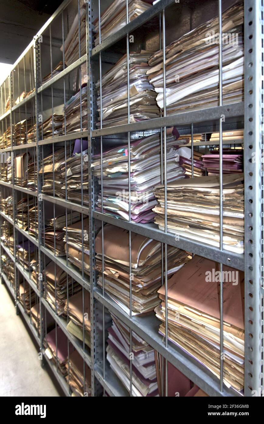 Open shelves with old files, folders and documents in an archive room ...