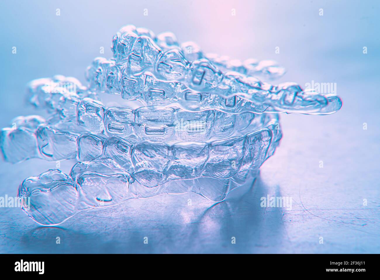 Invisible dental teeth brackets tooth aligners on blue background ...
