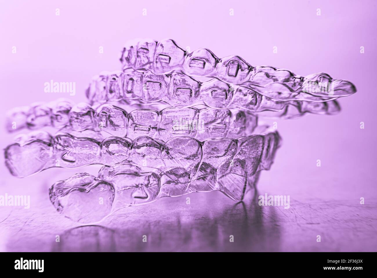 Invisible aligner teeth retainers on a pink background Stock Photo - Alamy