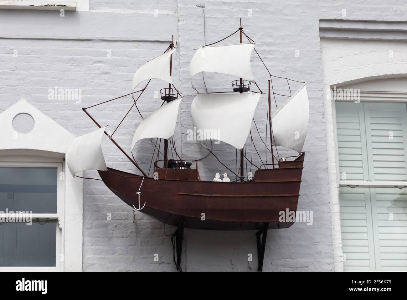 sailing ship decoration on the side of a whitewashed house in Porlock ...