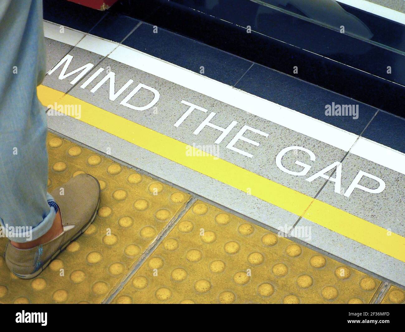 Mind the gap sign. text on train station platform. white text signal on ...