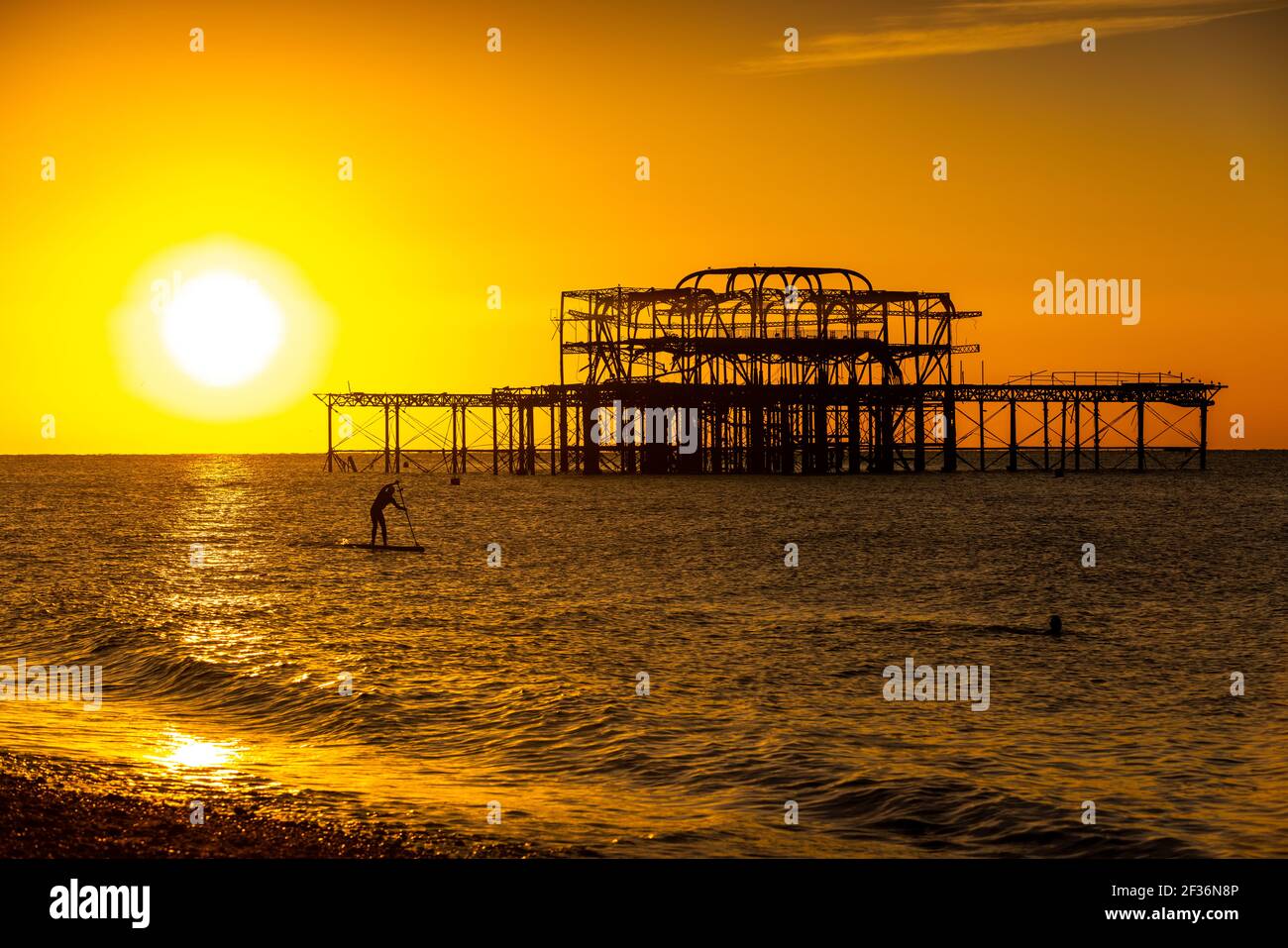 A member of the public paddle boarding in the sea next to the abandoned ...