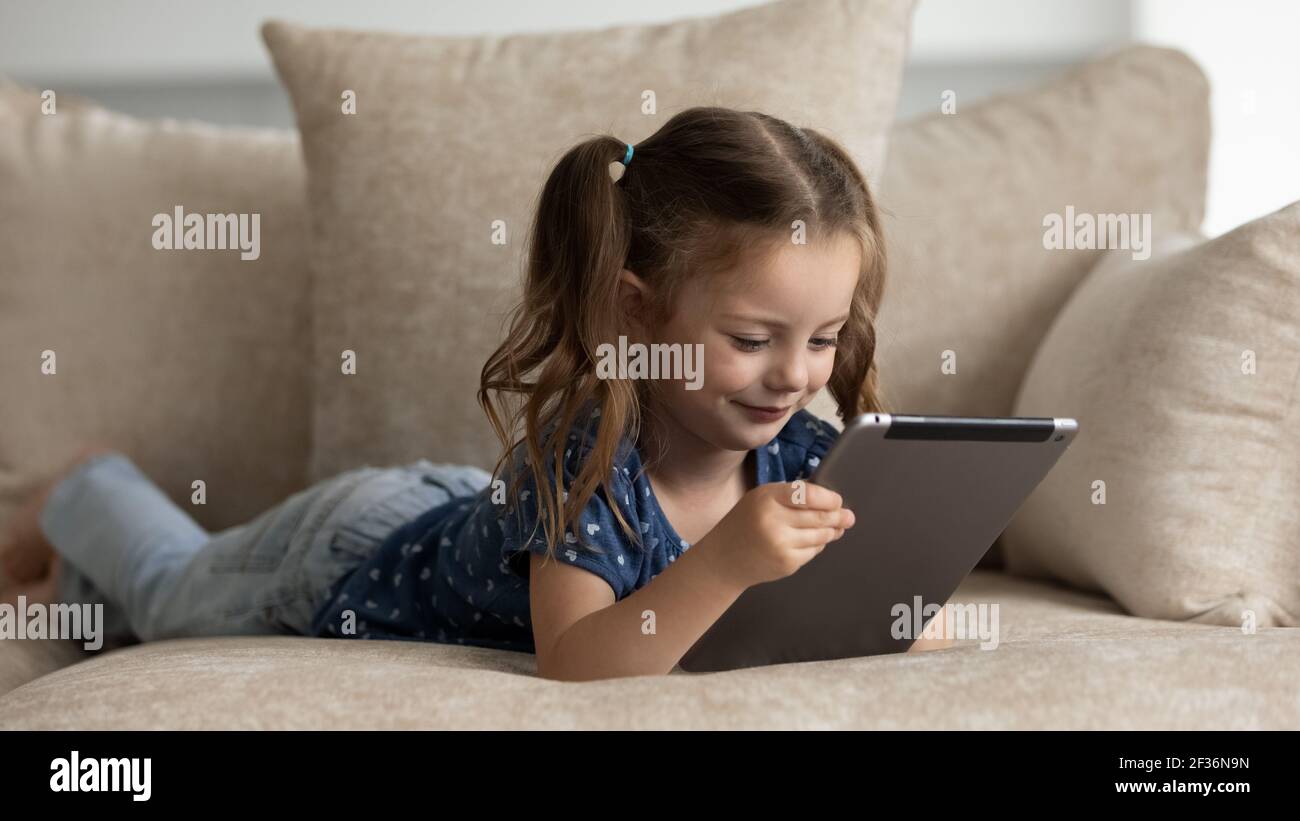 Little Caucasian kid using tablet at home Stock Photo - Alamy