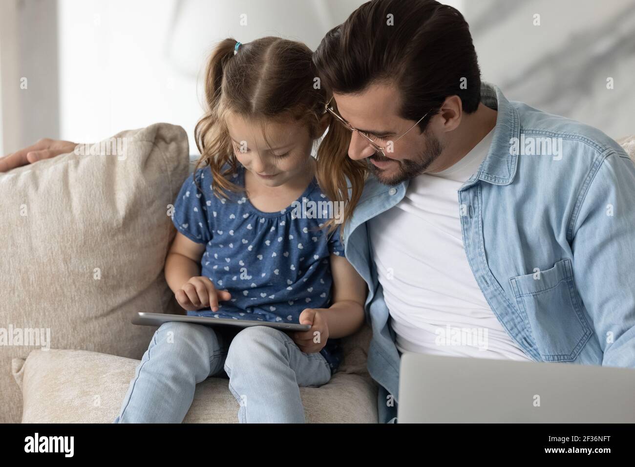 Caring dad and small daughter use tablet Stock Photo - Alamy