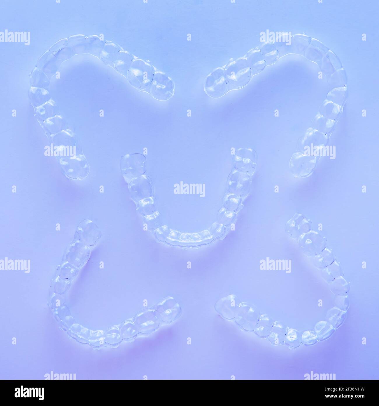 Invisible dental teeth brackets tooth aligners on blue background ...
