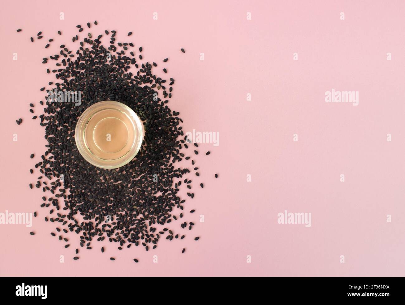 Fresh sesame seed and cosmetics sesame oil on pink background. Top view ...