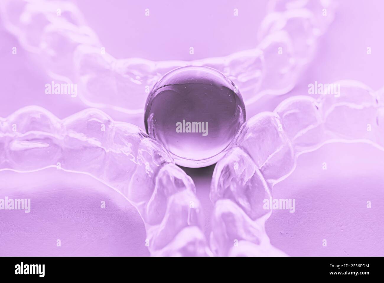 Invisible aligner teeth retainers on a pink background Stock Photo - Alamy