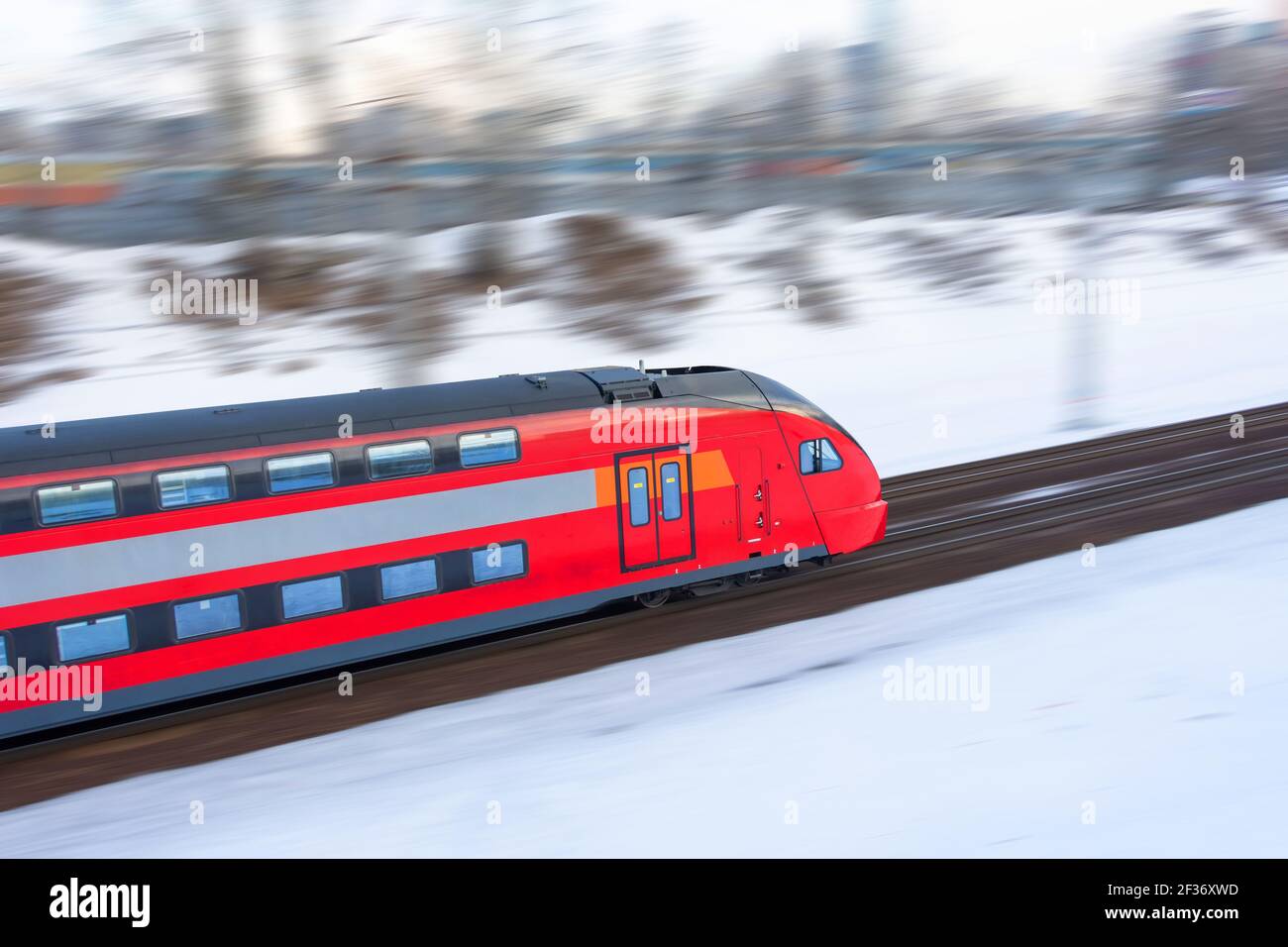 High speed double decker express train arrives at a station in the city ...