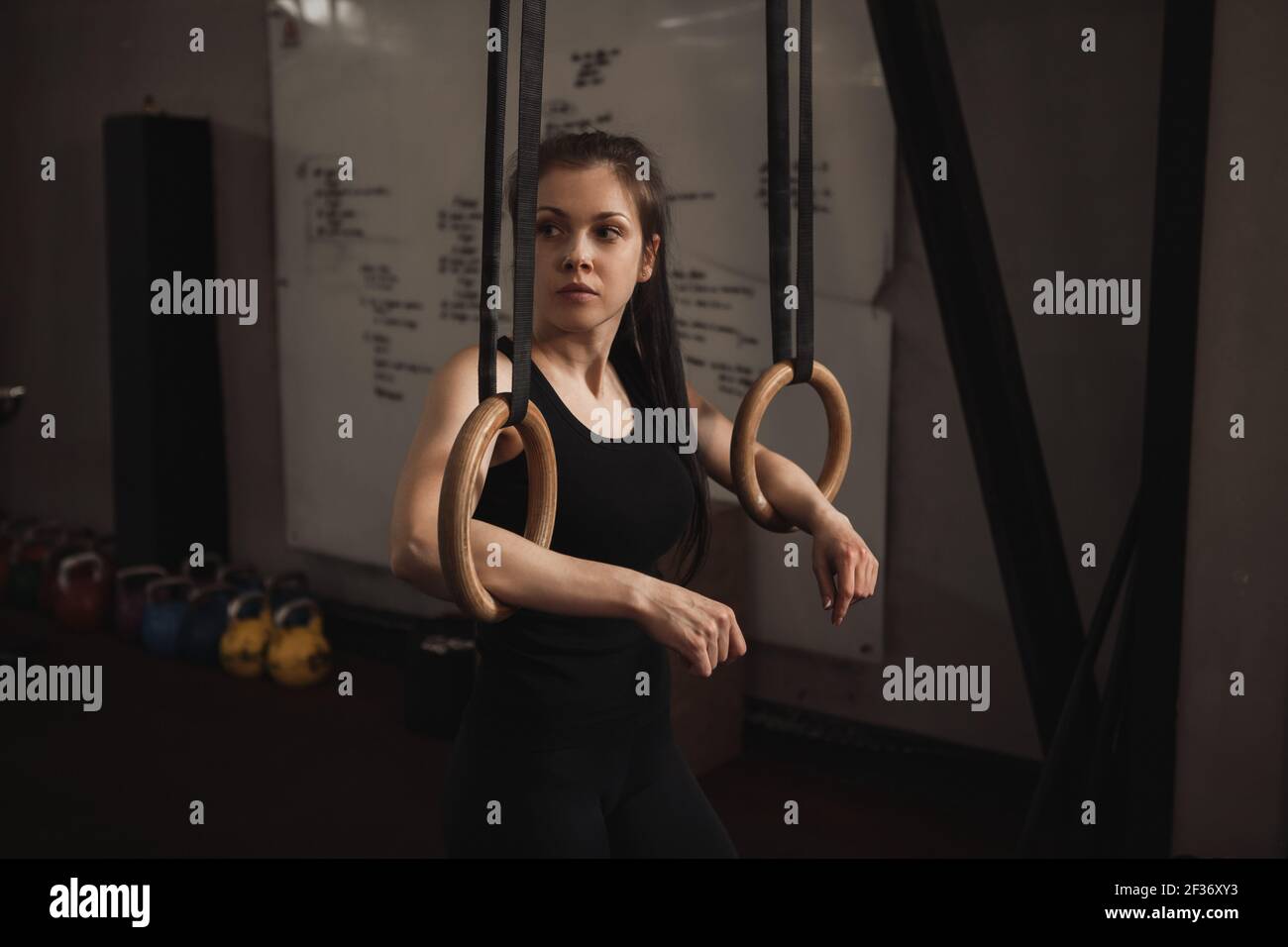 Female gymnast resting after exercising on gymnastic rings Stock Photo ...