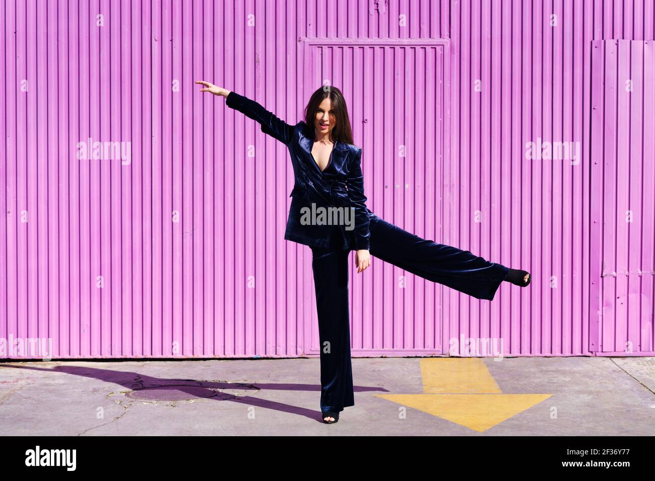 Woman wearing blue suit dancing near pink shutter Stock Photo - Alamy