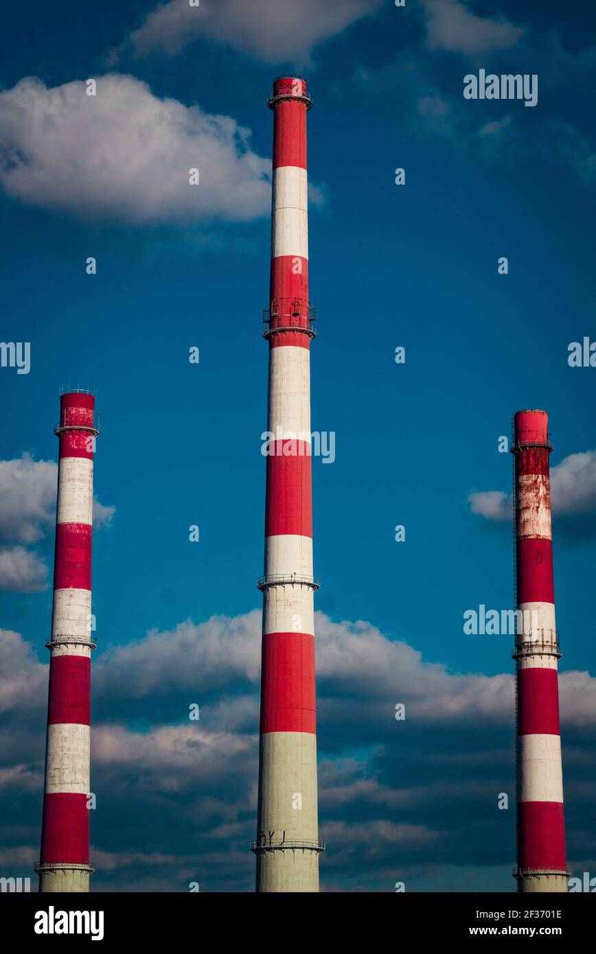three chimneys on cloudy sky background Stock Photo - Alamy