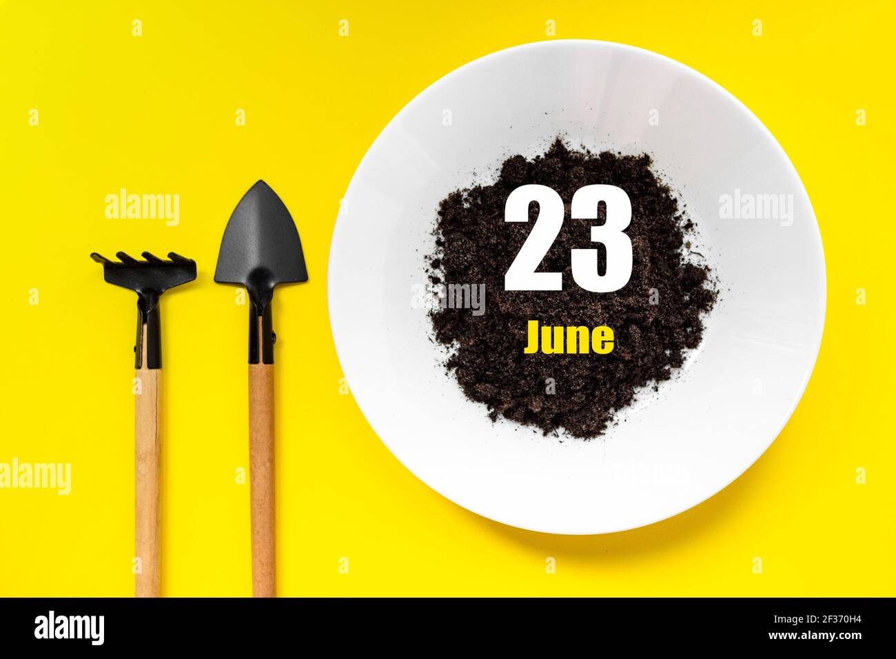 June 23rd. Day 23 of month, Calendar date. White plate of soil with a ...