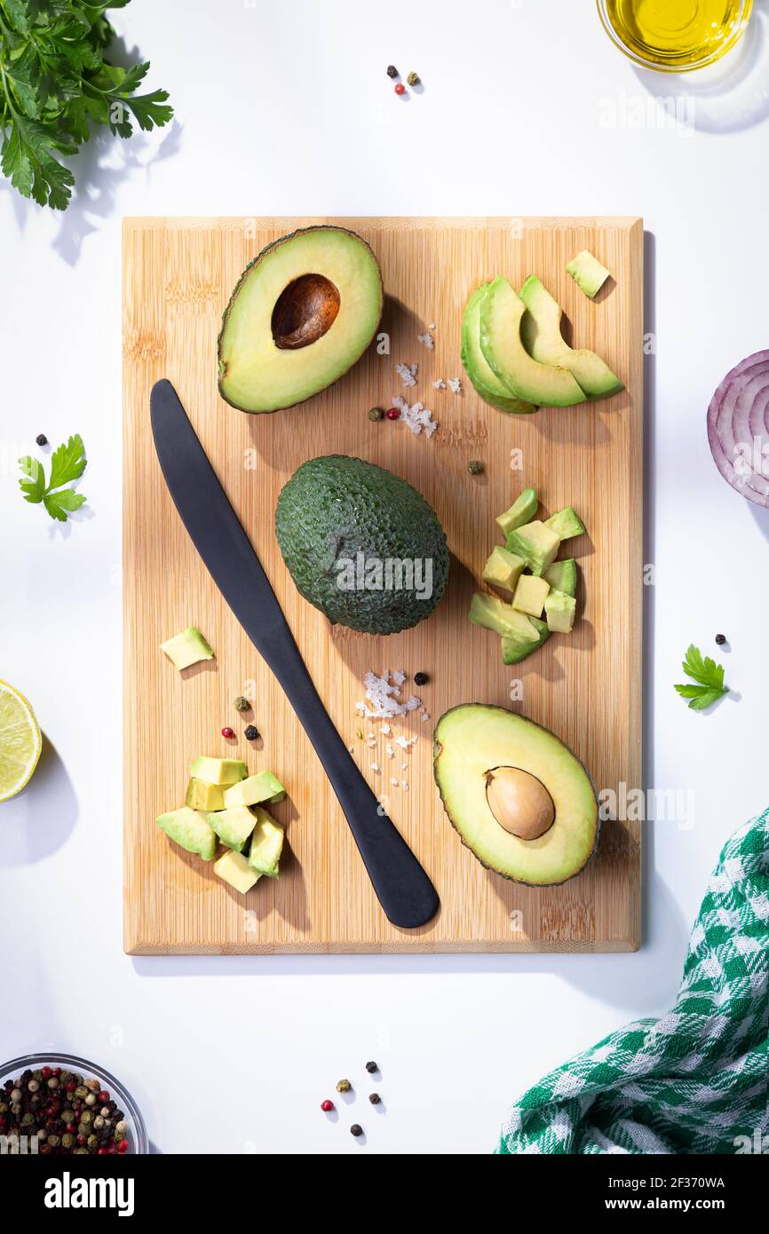 Flat lay composition of fresh avocados on wooden base. Vertical format ...