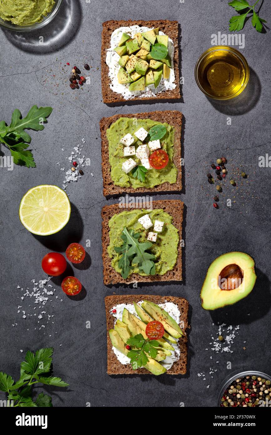 Flat lay composition of avocado toast on dark base. Vertical format ...