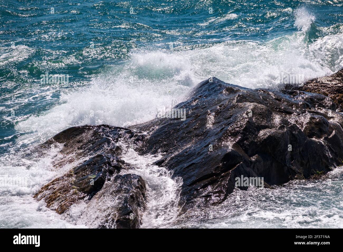 Sea water beats against rocks. Sea waves of dark water beat against the ...