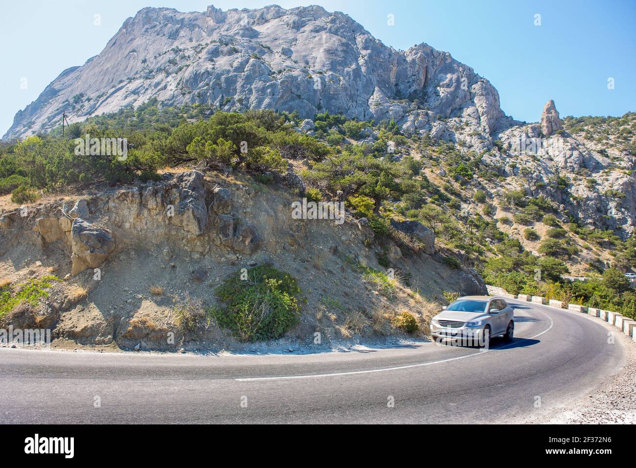 Crossover Moves along a winding road in the mountains during the day ...