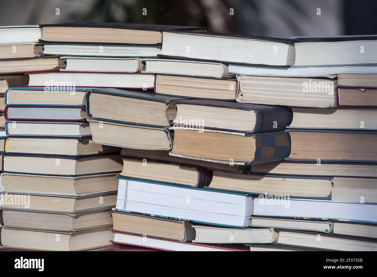 A stack of old and new books of different sizes and shapes stacked in a ...