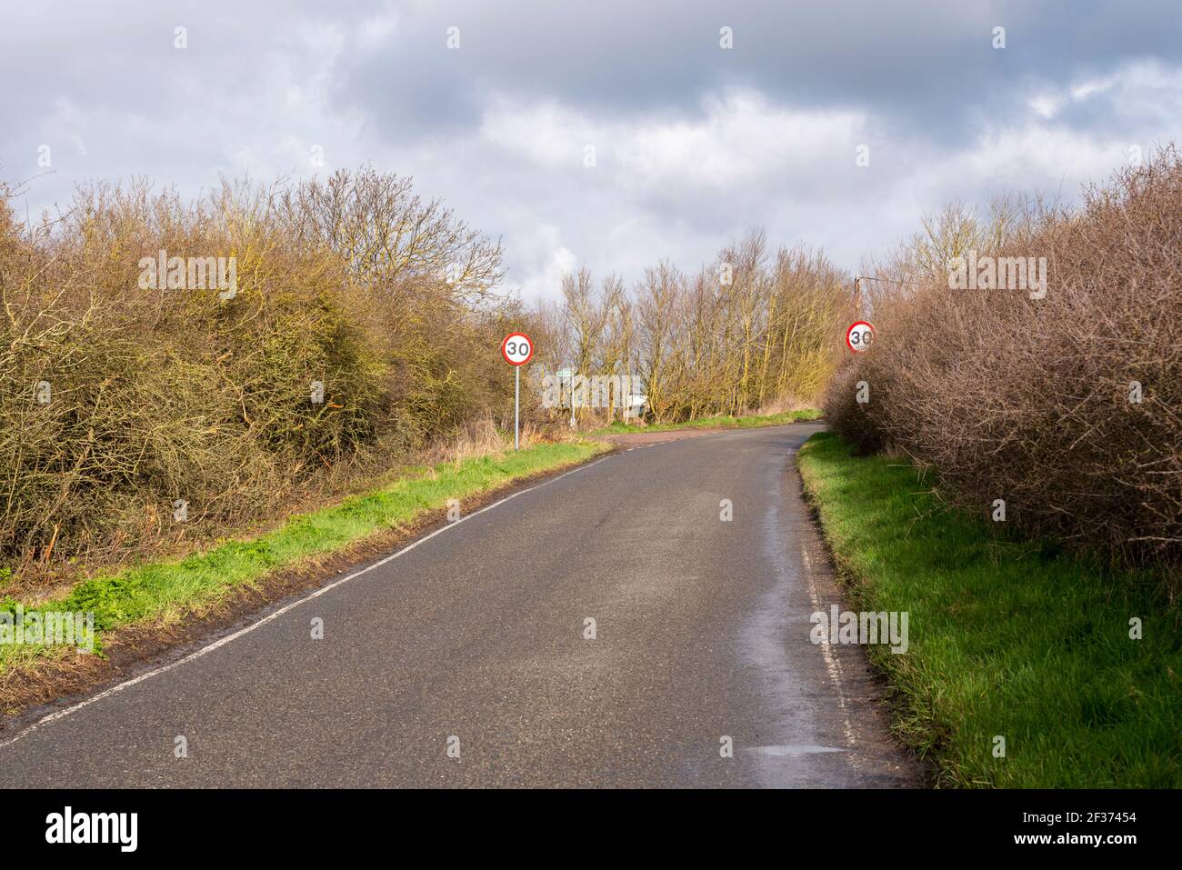 Country road, approaching a 30mph speed limit and a blind bend, at ...