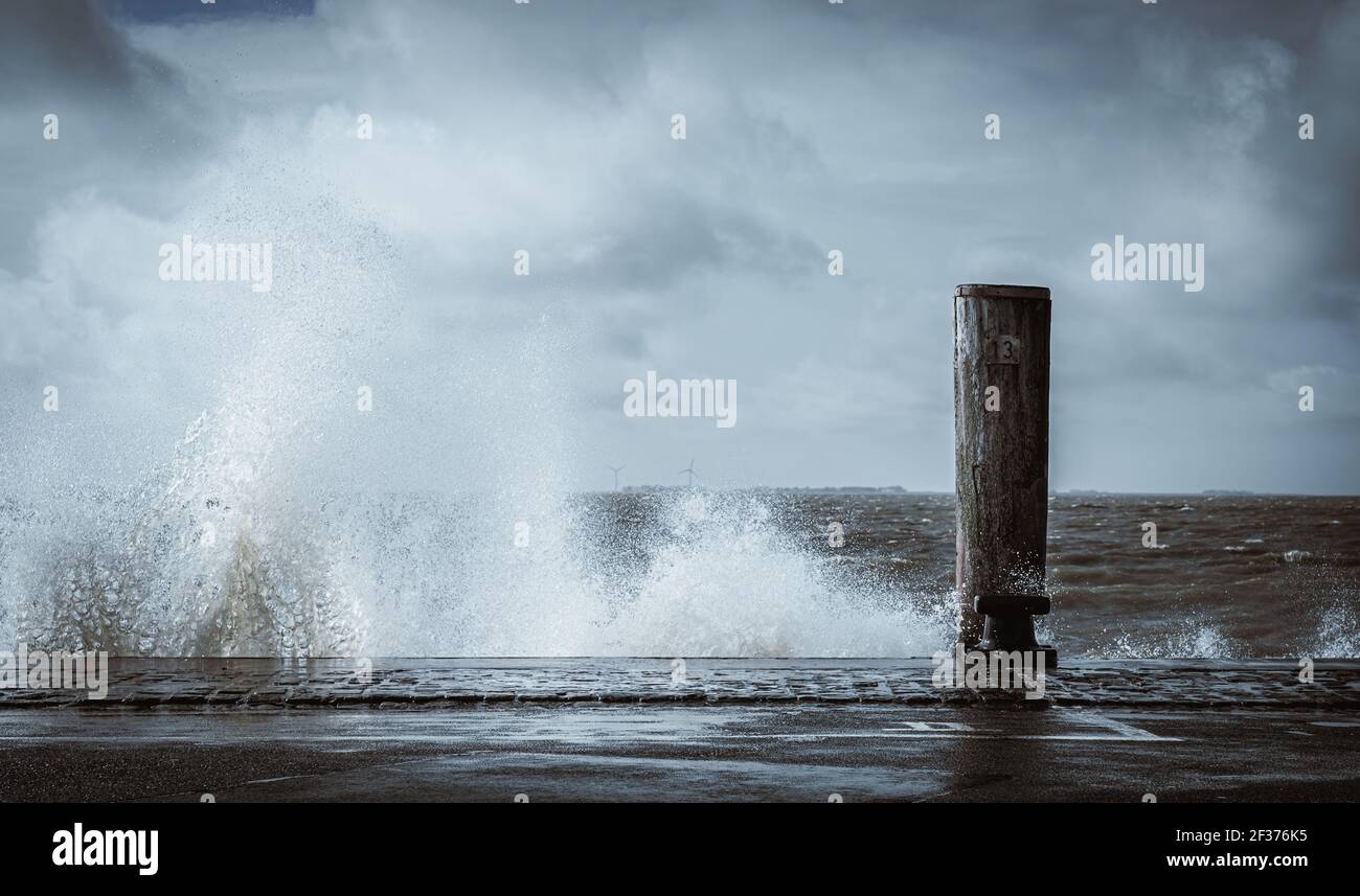 Waves at a harbour splashing against the shore with large amount of ...