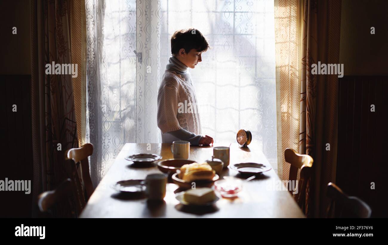 Poor sad small girl setting table indoors at home, poverty concept ...