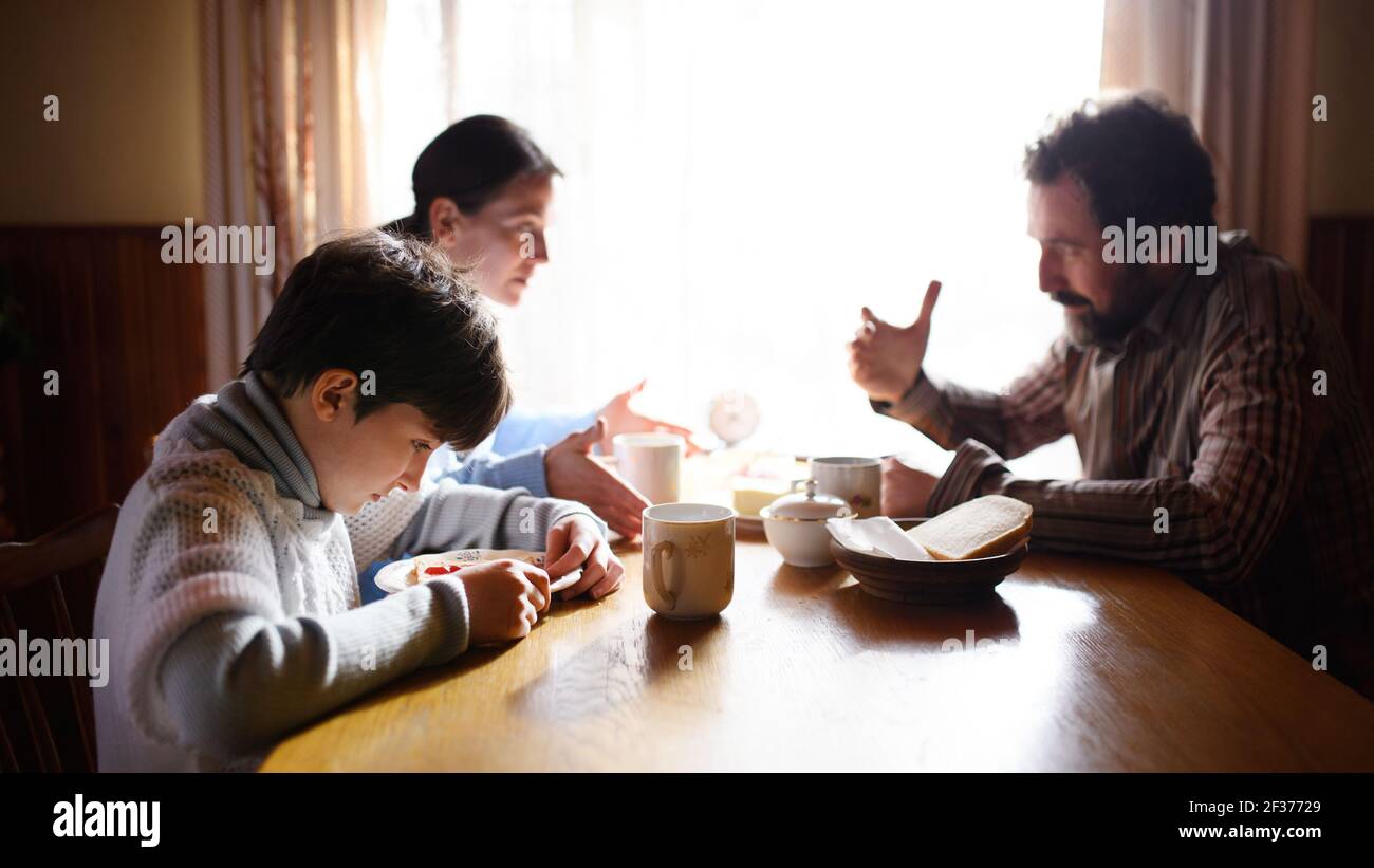 Portrait of poor sad small girl with parents indoors at home, poverty ...
