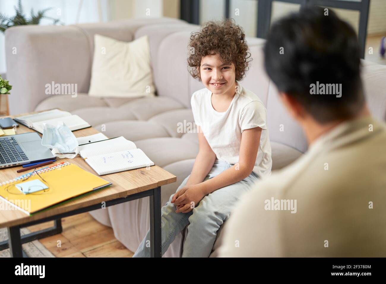 Happy latin boy communicating with his father, doing homework while ...