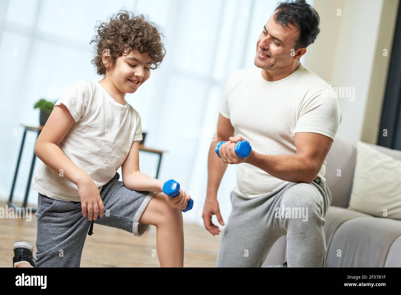 Family workout. Sportive latin middle aged father teaching his son ...