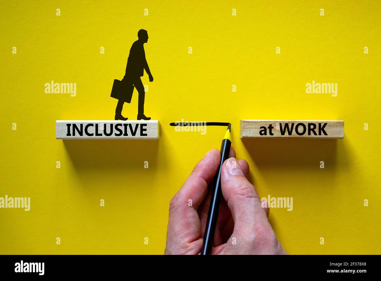Inclusive at work symbol. Wooden blocks with words 'Inclusive at work ...