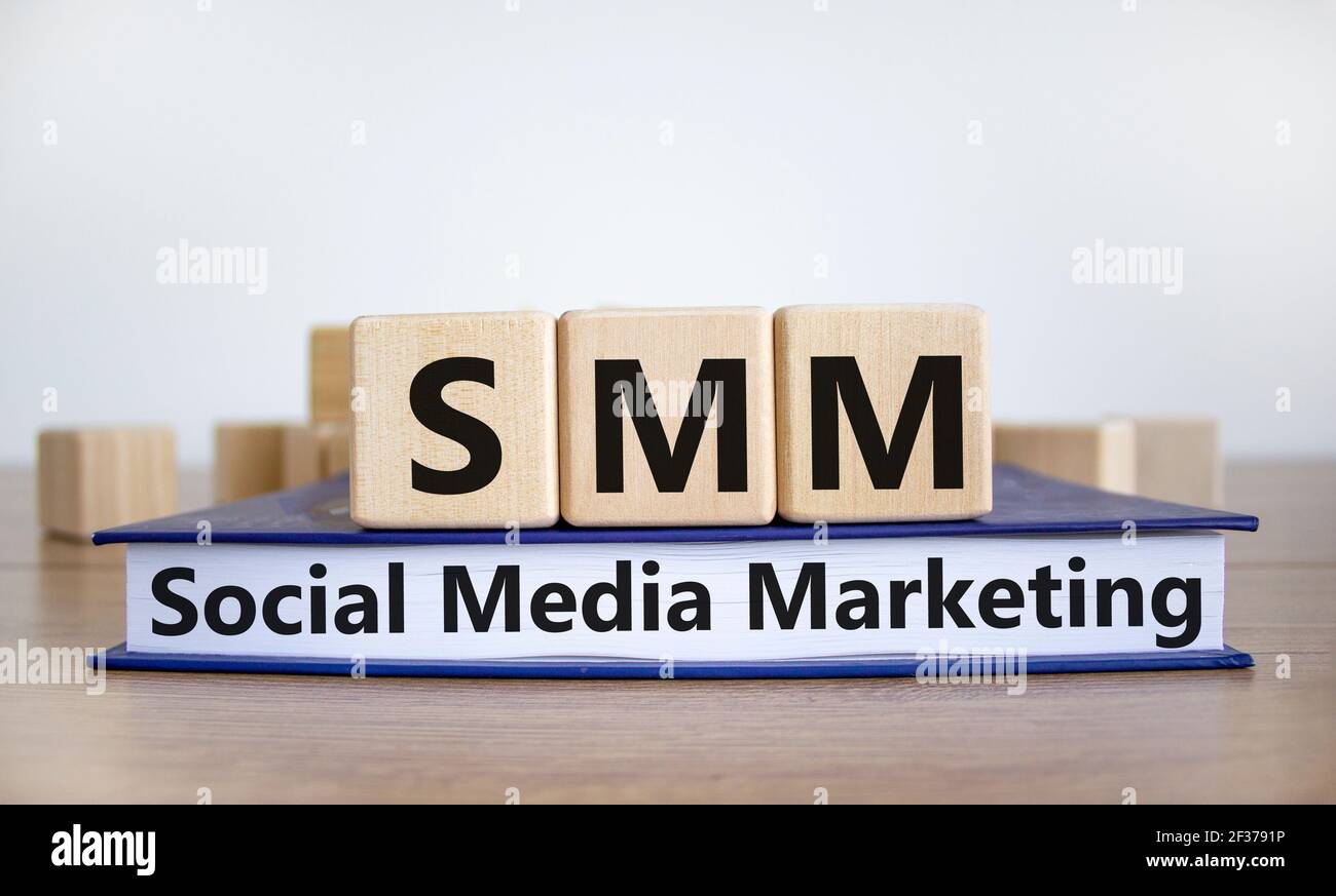 SMM, social media marketing symbol. Wooden cubes on book with word 'SMM ...