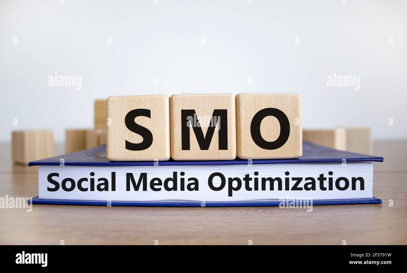SMO, social media optimization symbol. Wooden cubes on book with word ...
