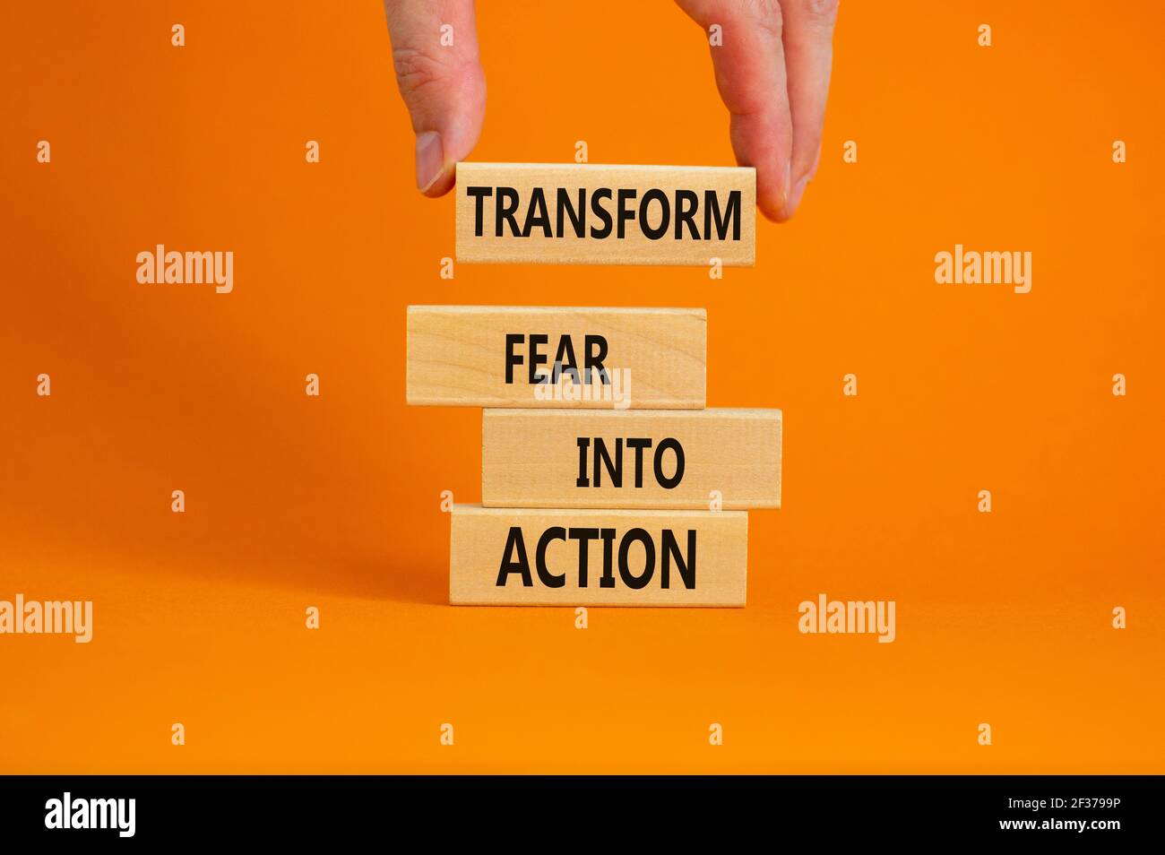 Transform fear into action symbol. Businessman holds wooden blocks with ...