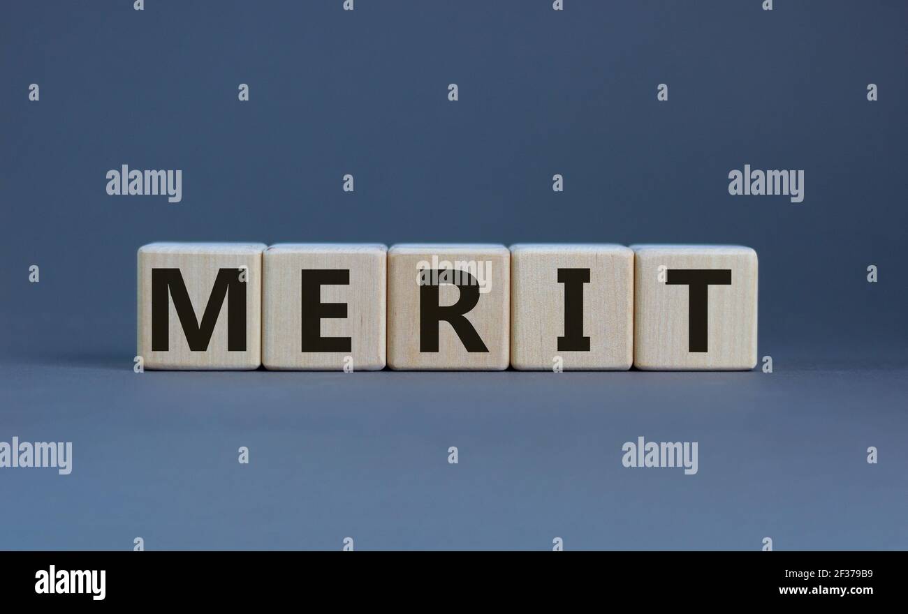 Merit symbol. Wooden cubes with the word 'merit'. Beautiful grey ...