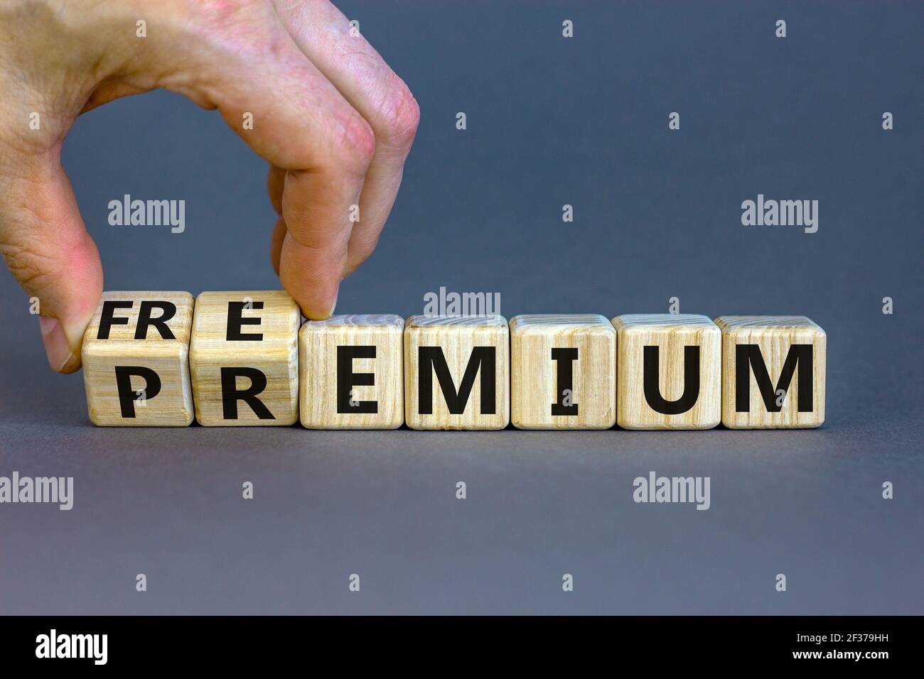 Premium or freemium symbol. Businessman turns wooden cubes and changes ...