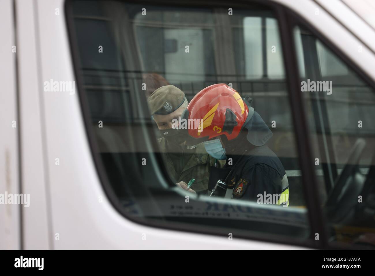 Firemen and other emergency services workers wearing face masks are ...