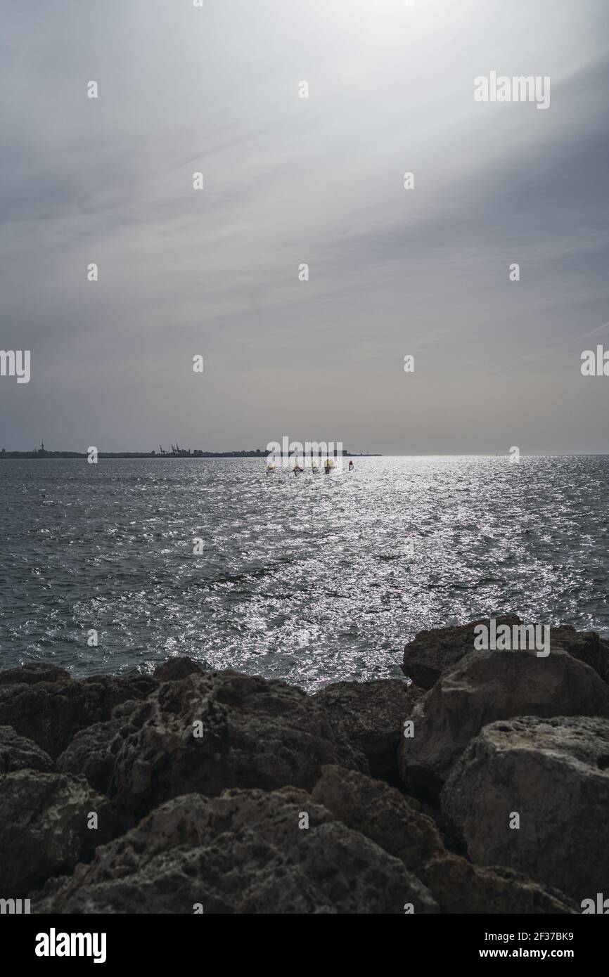 A vertical shot of the sea surrounded by rocks under the sunl Stock ...