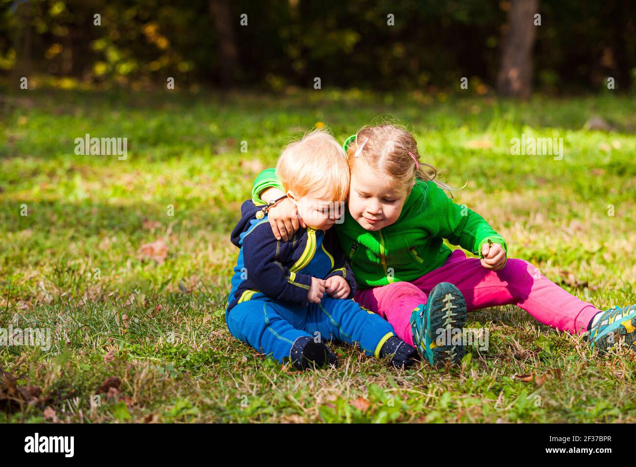 The cheerful girl is hugging her crying brother outdoor Stock Photo - Alamy