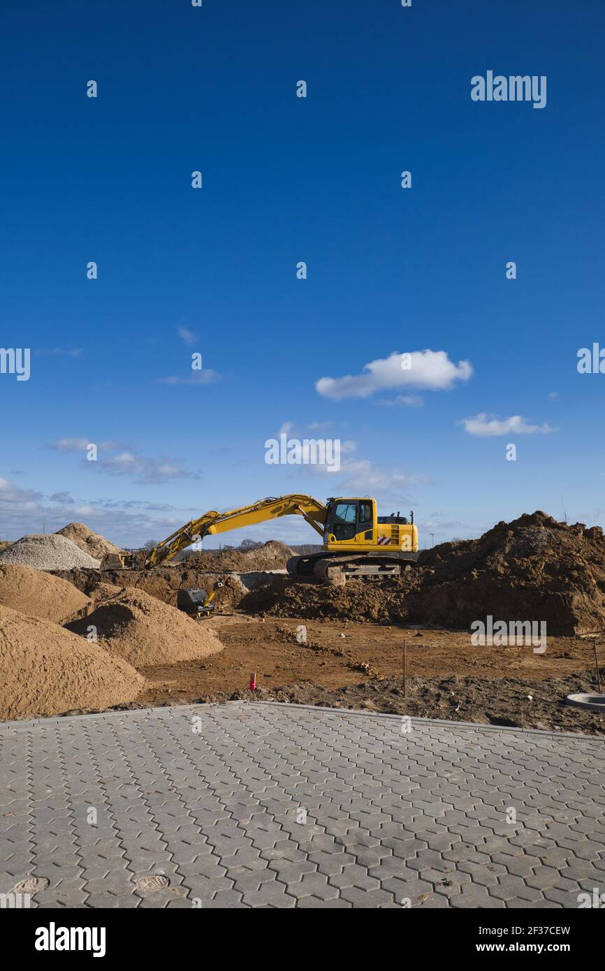 A vertical shot of a new development area, and construction vehicle, in ...