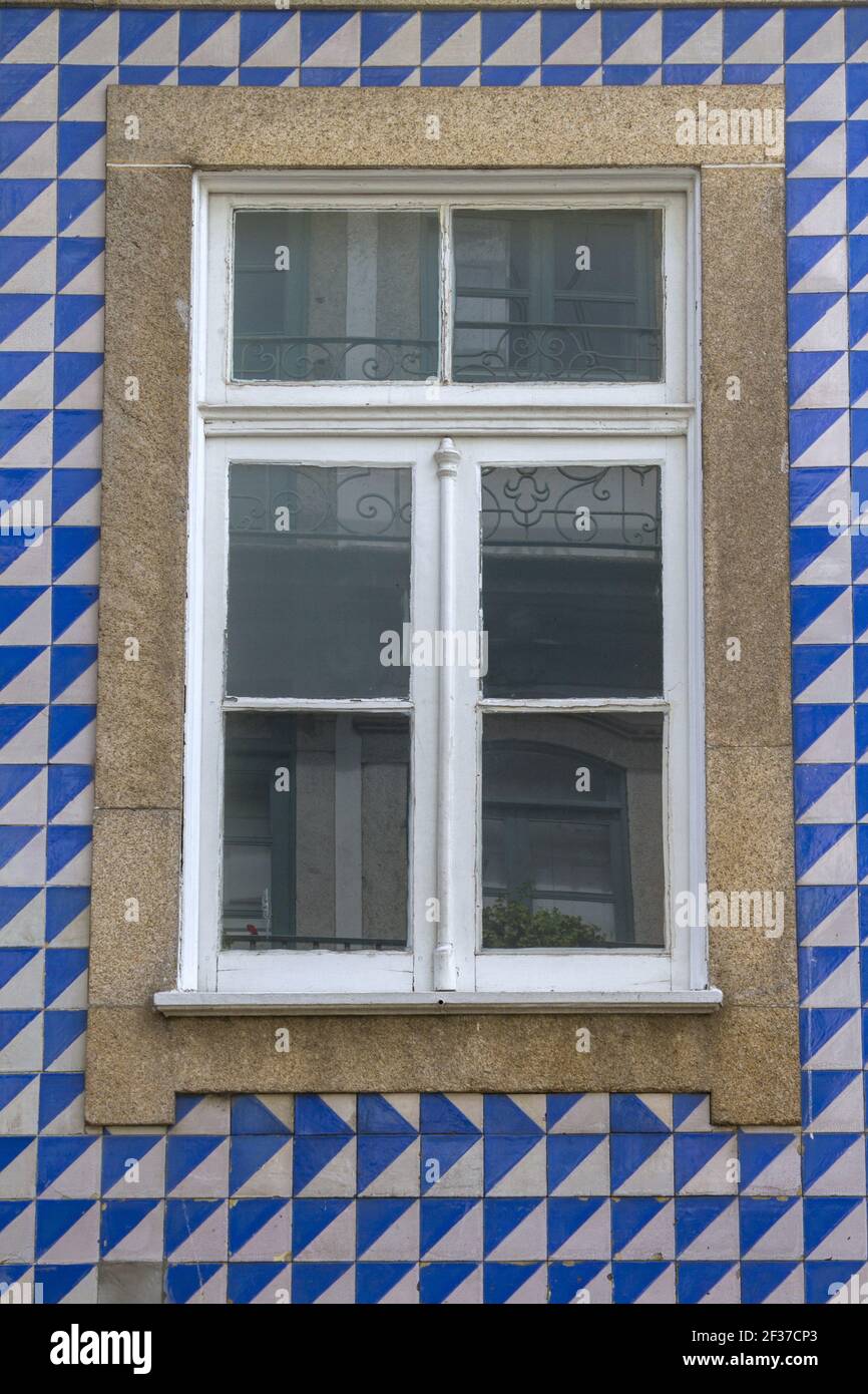 A vertical shot of a beautiful old window with the white-blue ceramic ...