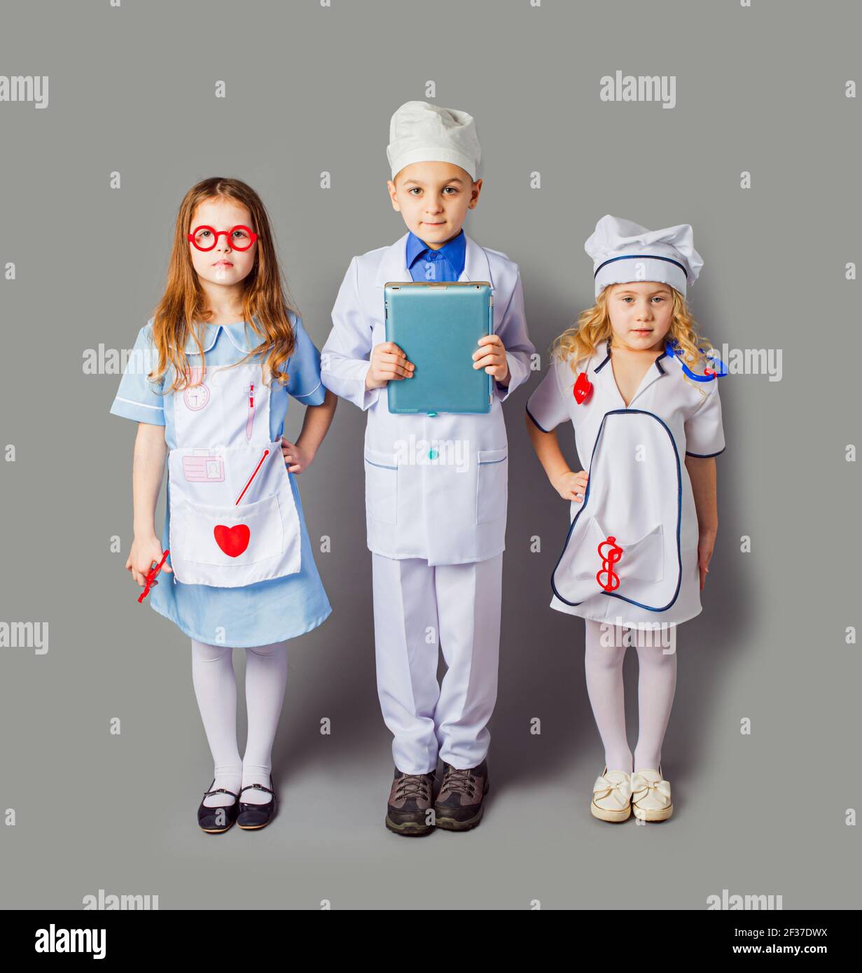 Cute little children dressed as doctors on grey Stock Photo - Alamy