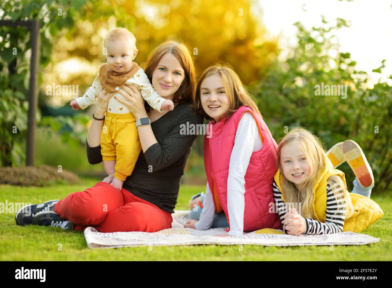 Mother and three children having fun on autumn day in city park ...